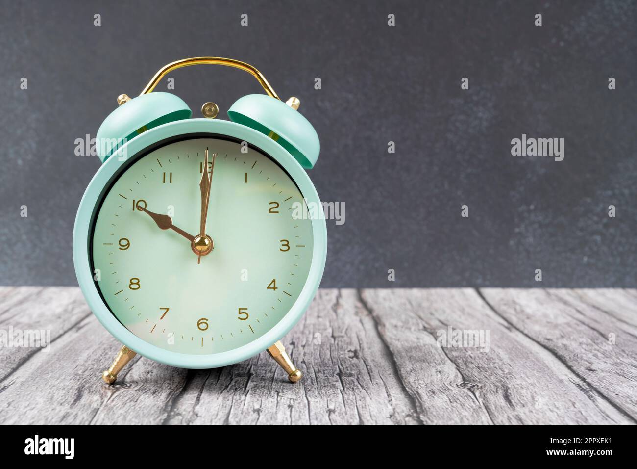 Vintage retro alarm clock ten time o'clock on table wood with dark ...