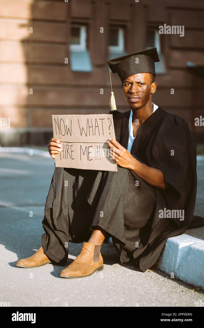 Poor black guy sitting with cardboard poster on street looking for job ...