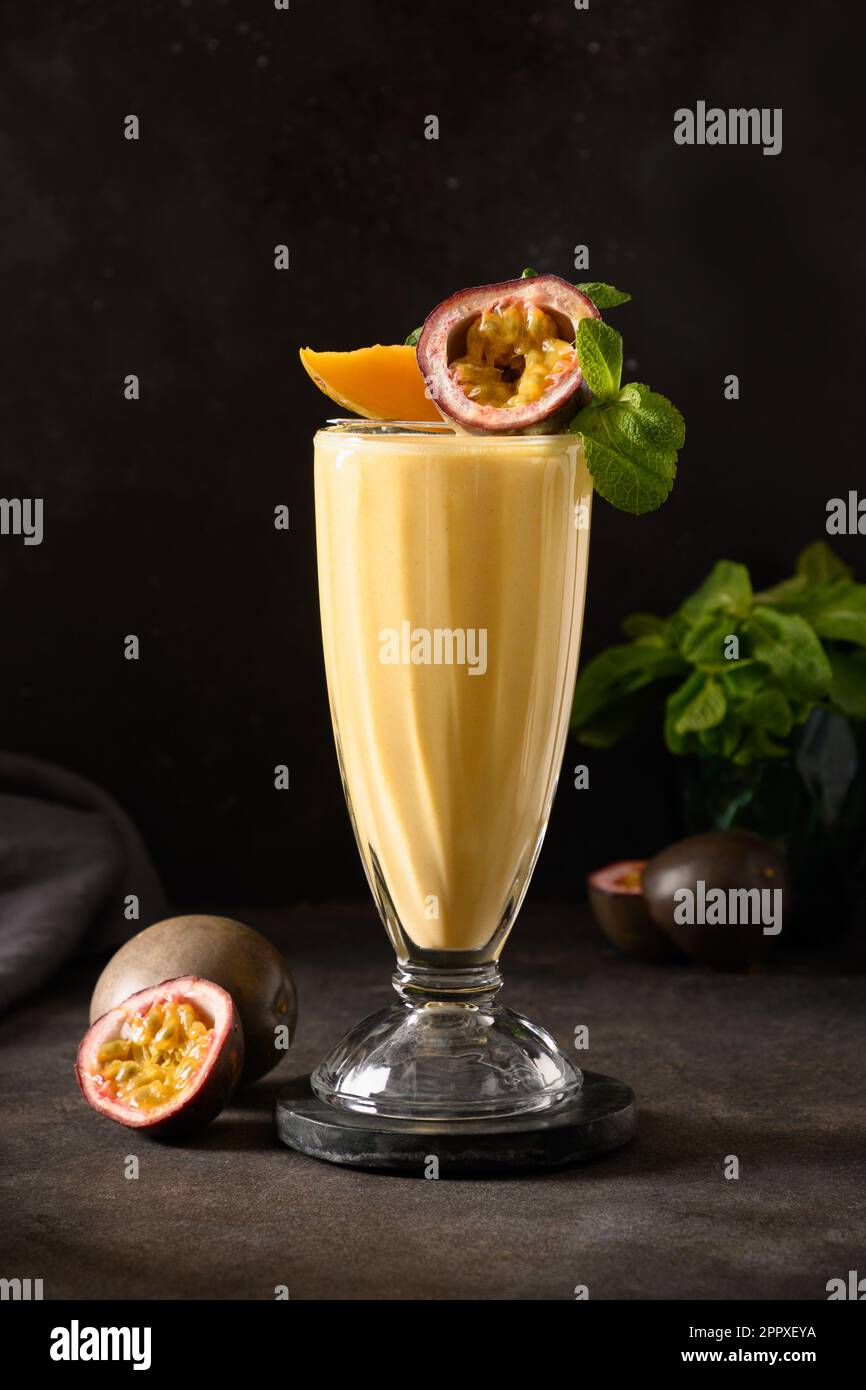 Passion Fruit and mango lassi, smoothie or milkshake on black ...