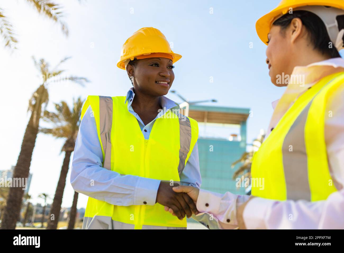Side view of African American engineers in yellow waistcoat uniform ...