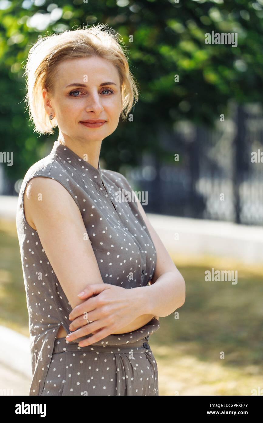 Portrait of attractive looking 40 years old woman standing half turn ...