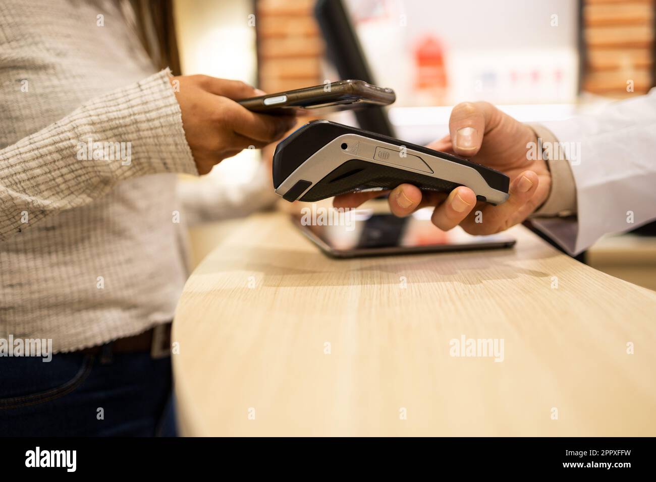 Side view of crop anonymous female customer paying contactless using ...