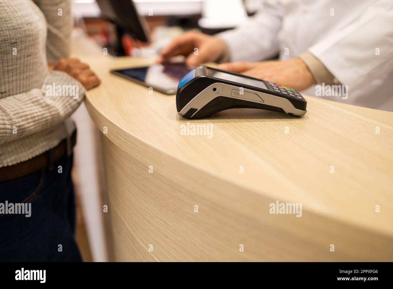 Anonymous female customer talking to crop man near counter with modern ...