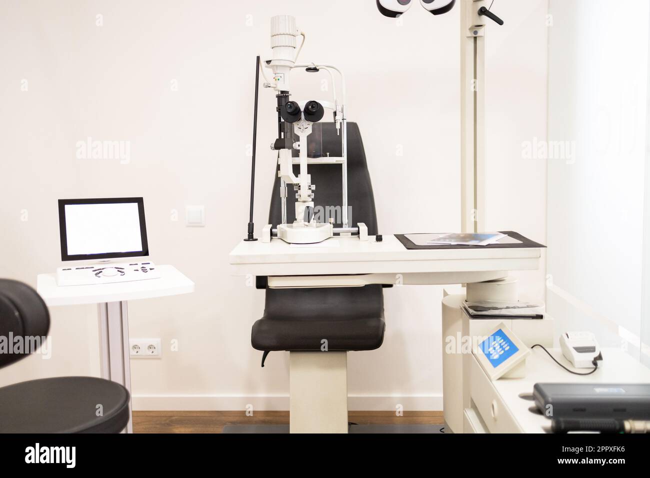 Contemporary workspace with white table and ophthalmic equipment placed ...