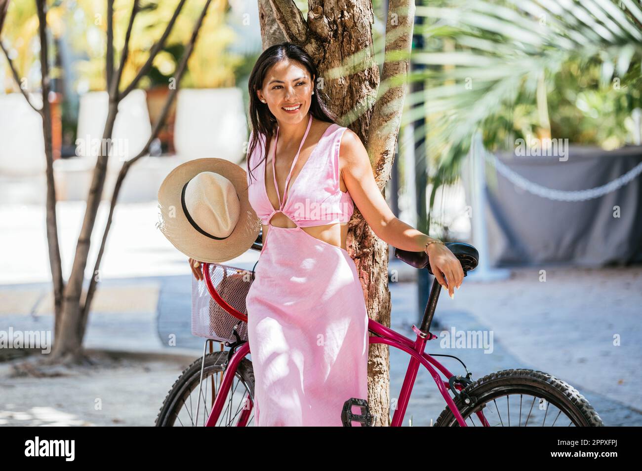 Full body of positive young mixed race female in summer dress and straw ...