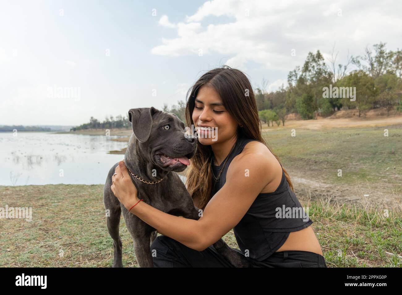 Side view of positive female owner with long hair stroking adorable ...