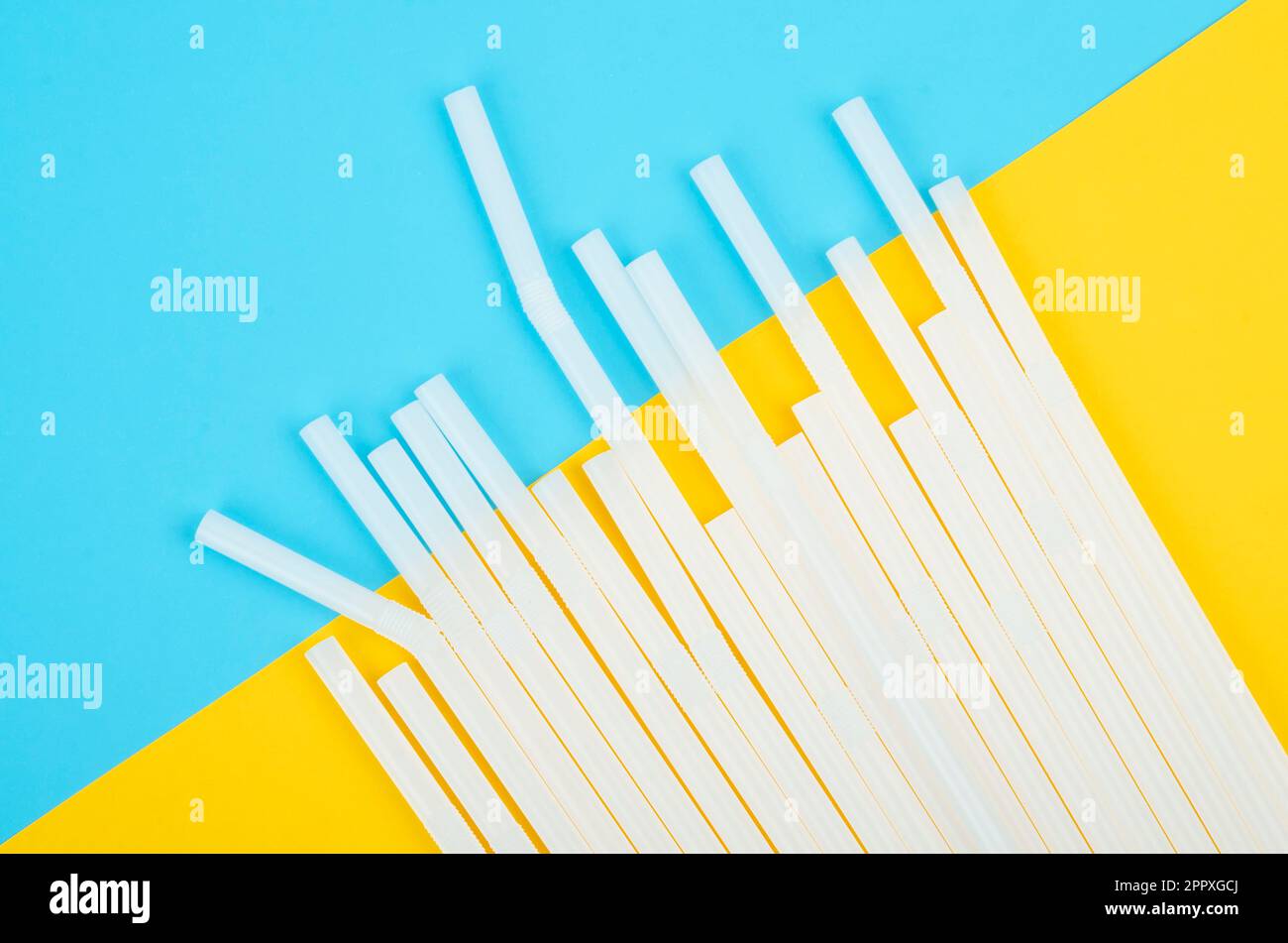 White plastic drinking straws on blue and yellow background. Garbage ...