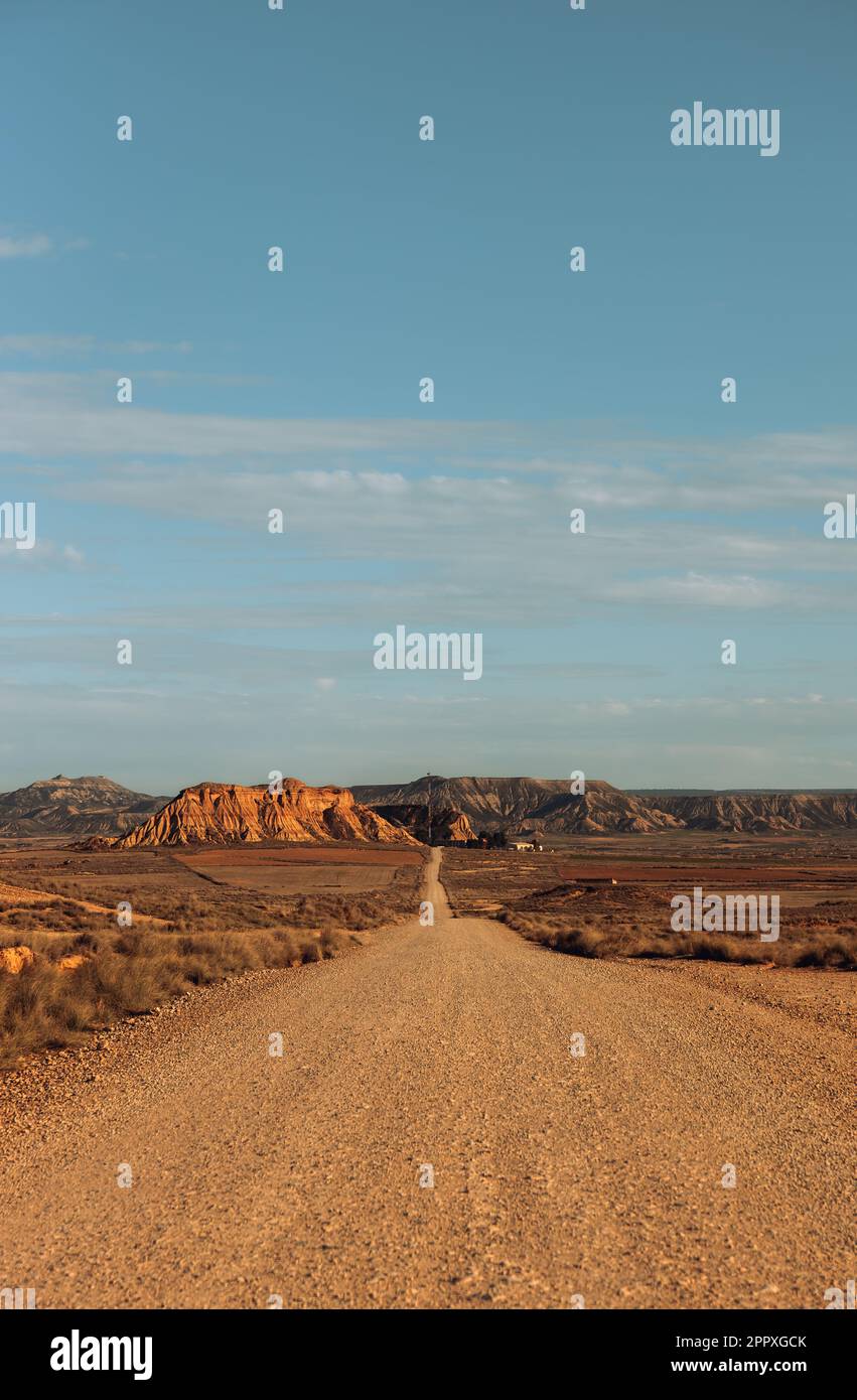 Picturesque landscape of empty sandy road in desert terrain located ...