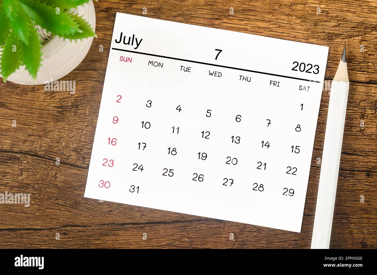 July 2023 Monthly calendar for 2023 year with pen on wooden background ...