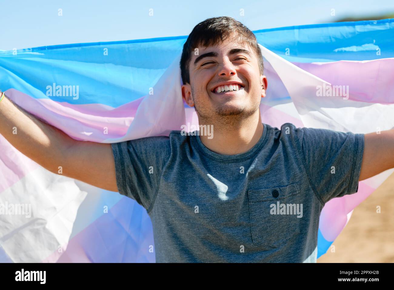 Excited transgender man after transitioning with closed eyes holding ...