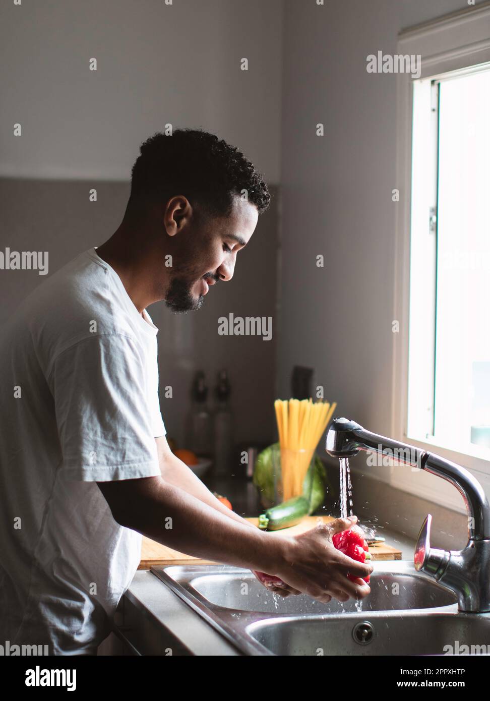 Side view of young ethnic African American male in casual t shirt ...