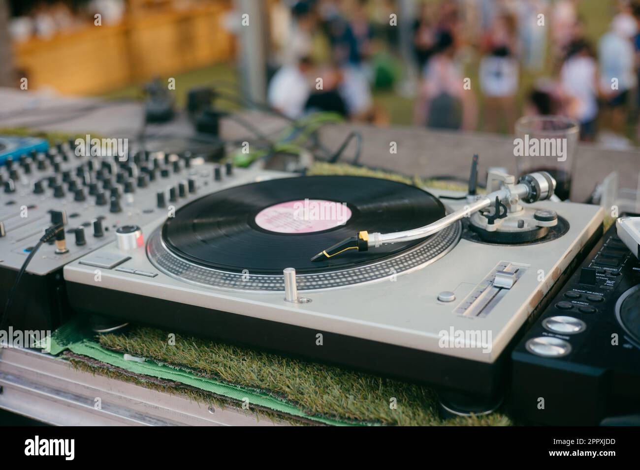 From above of modern DJ mixer placed on table on stage near crowd of ...