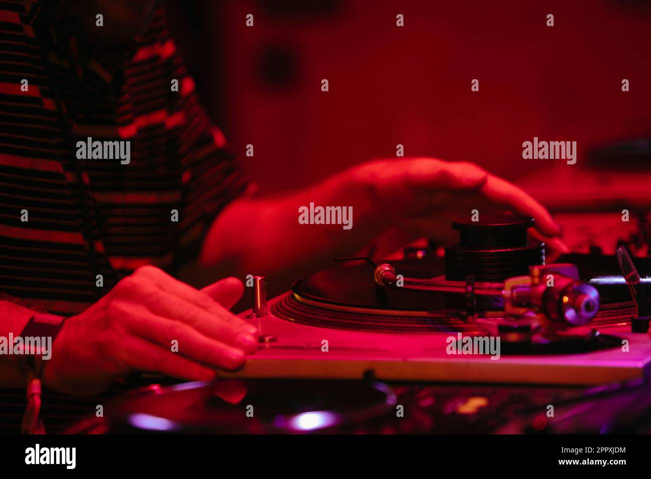 Side view of crop anonymous male DJ playing music on professional ...