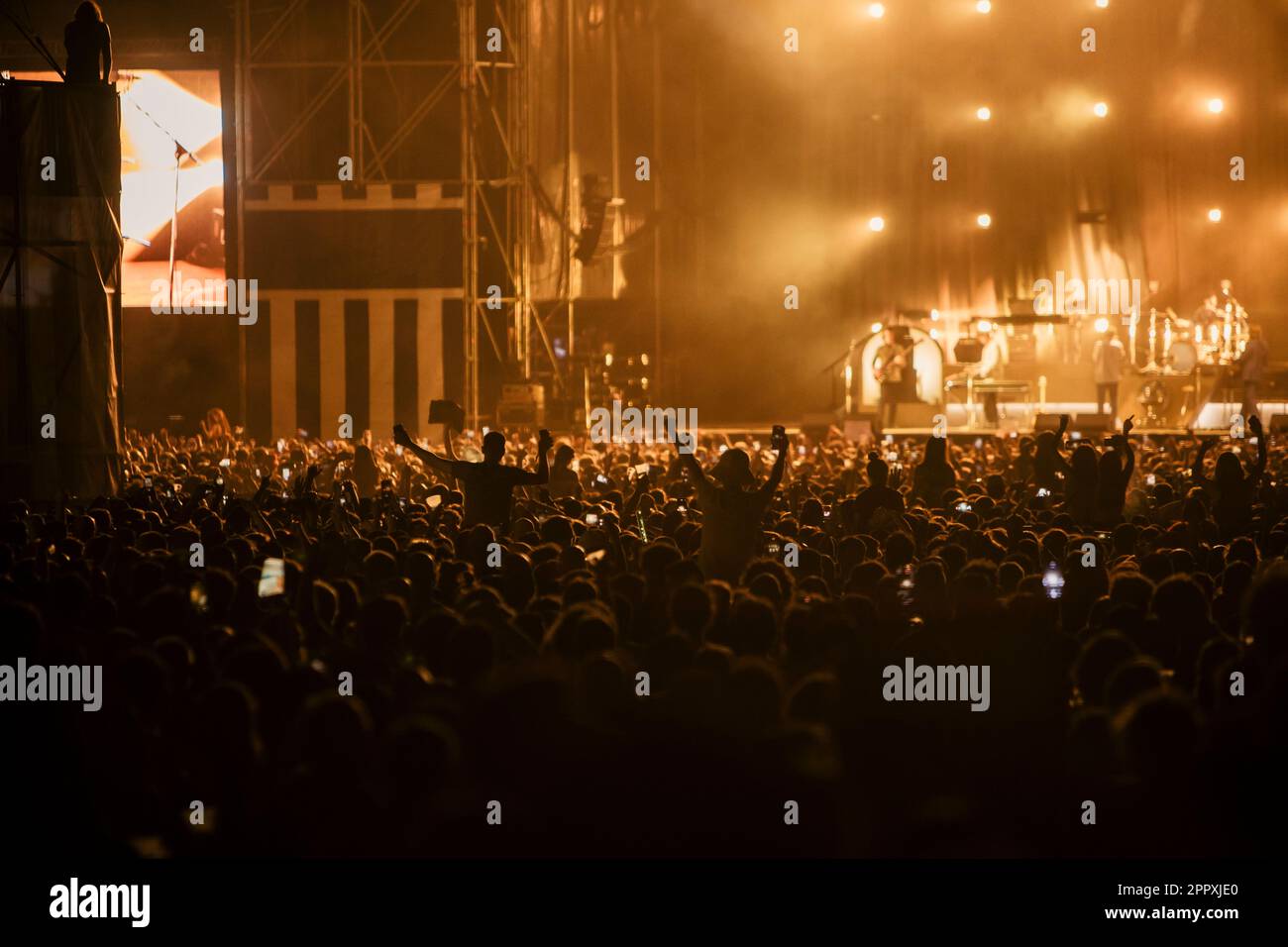 Crowd of people standing on dance floor near illuminated stage during ...