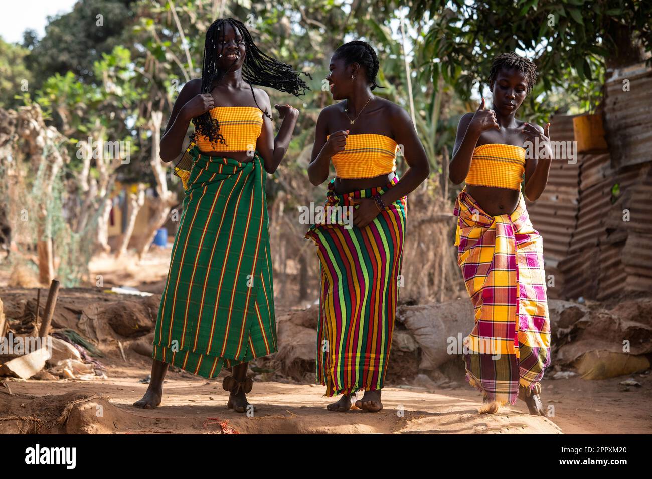 Full body of positive African girls in traditional clothes dancing on ...