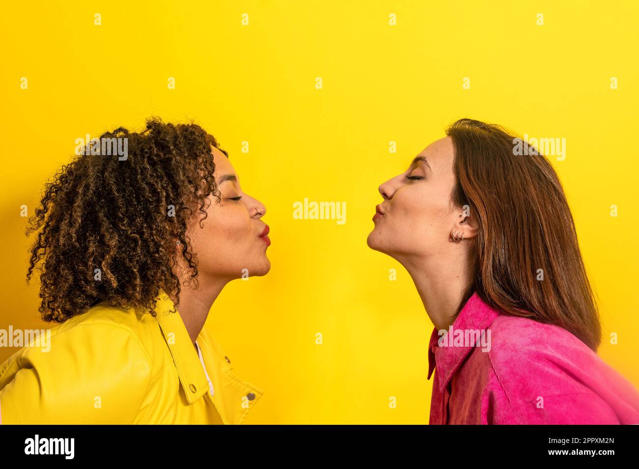 Side view of cheerful young diverse girlfriends in stylish outfits ...