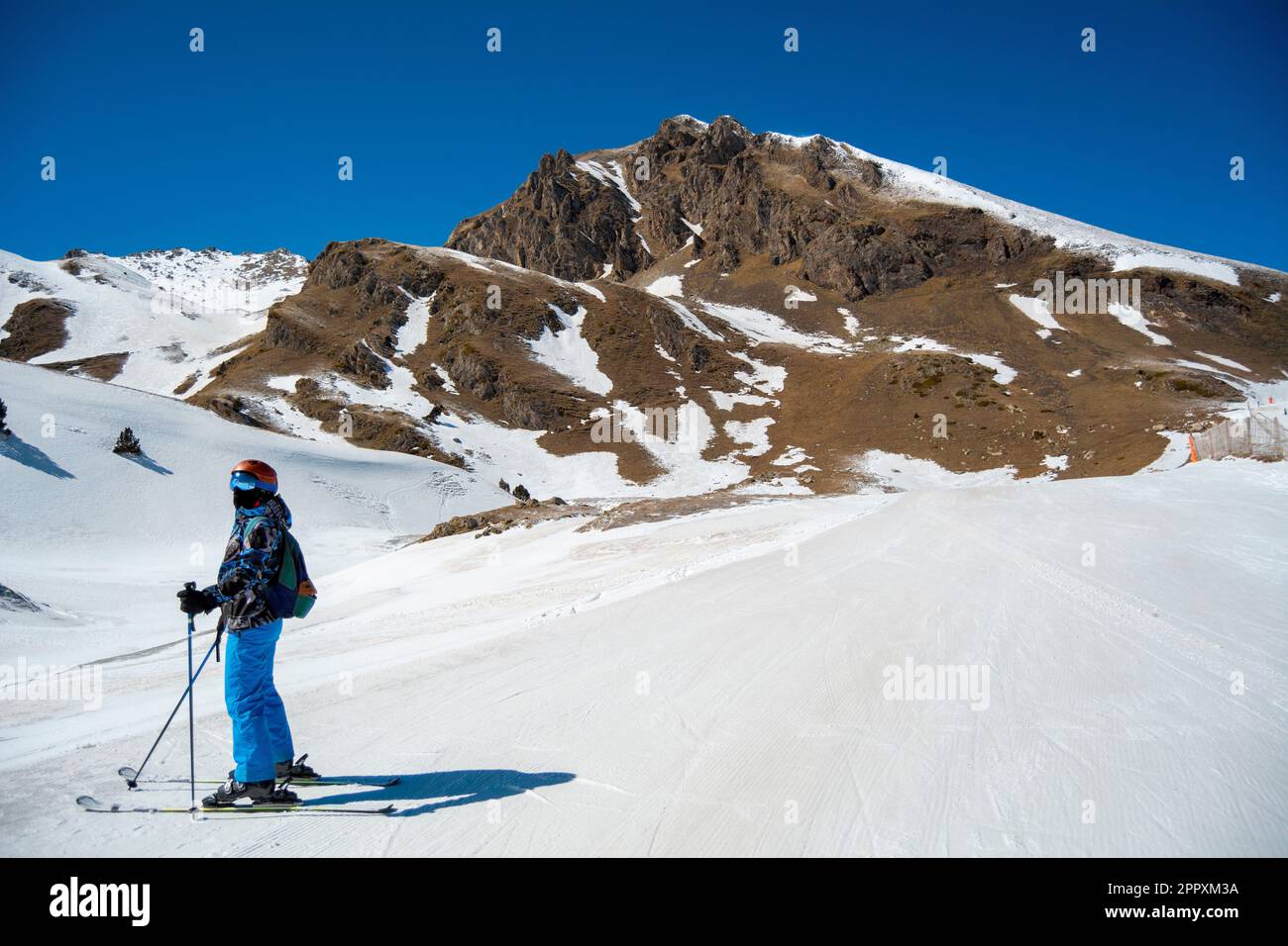 Full body side view of unrecognizable skier in warm ski suit and with ...