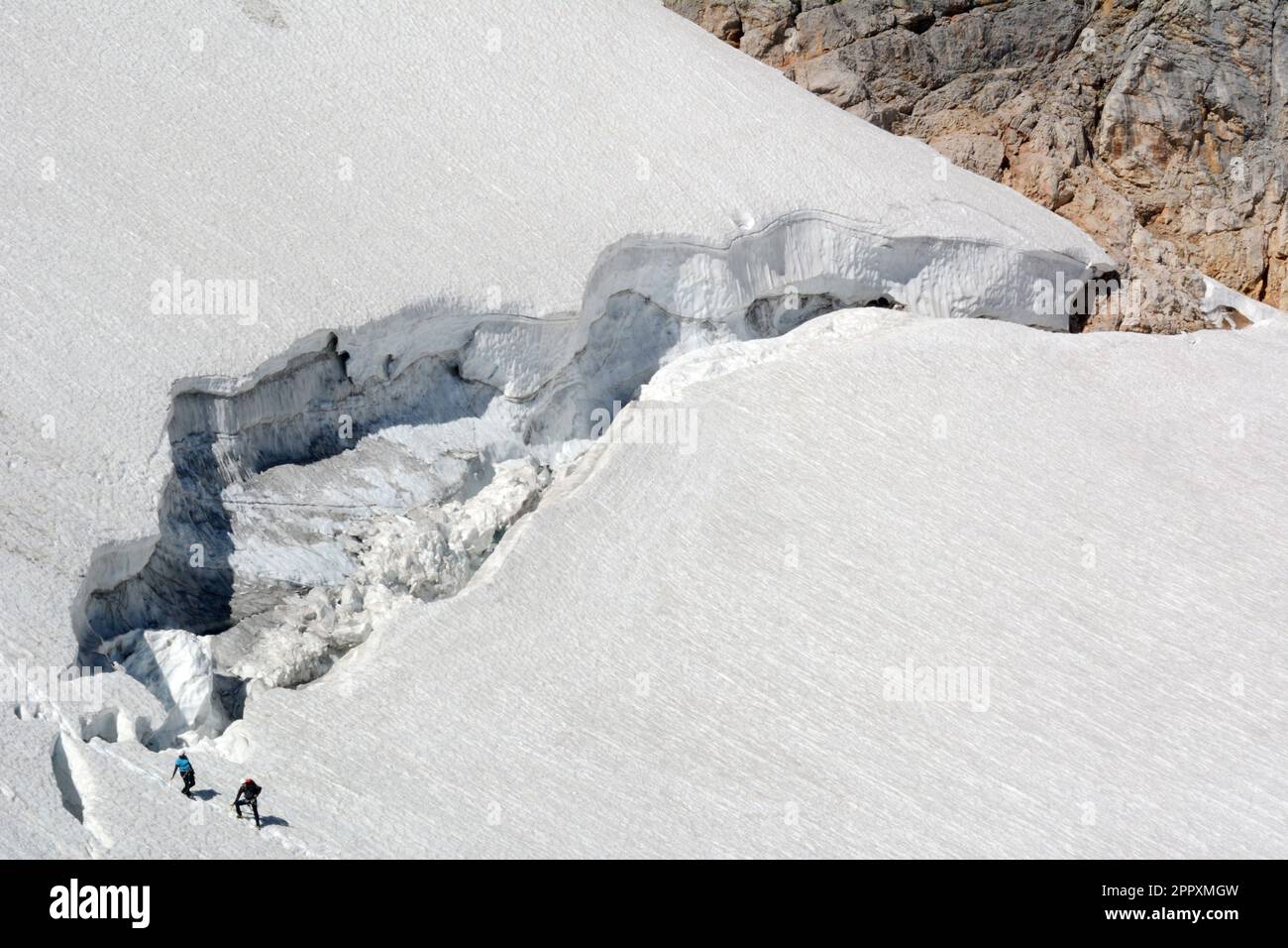 tiny mountain climbers by giant snow crack Stock Photo - Alamy