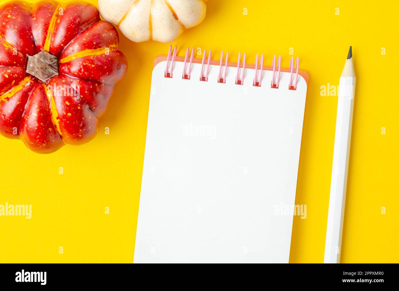 Open blank diary and pencil with pumpkins on yellow background for your ...