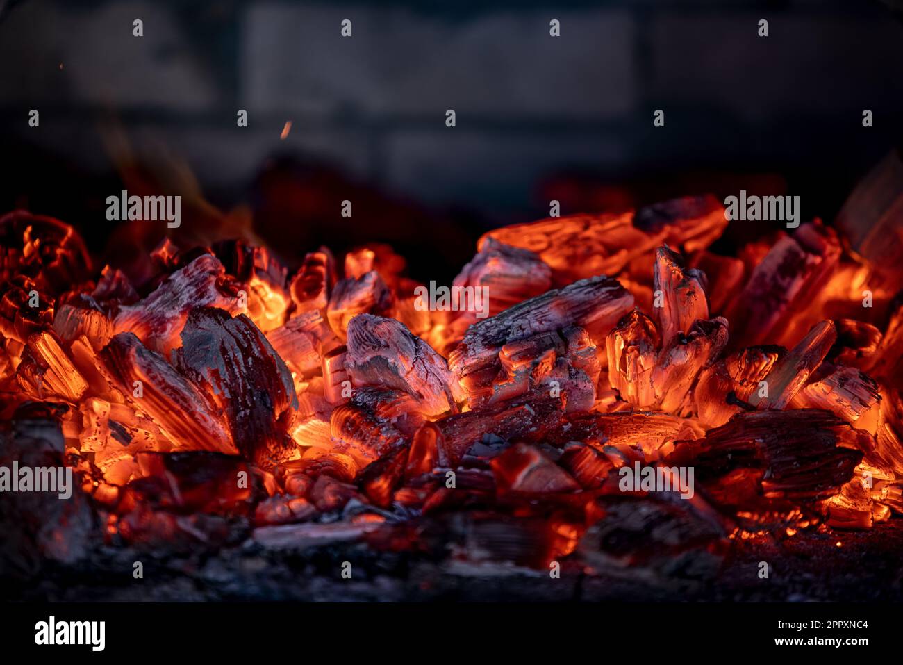 Flame of fire from hot burning coals in the fireplace. Heat from the ...