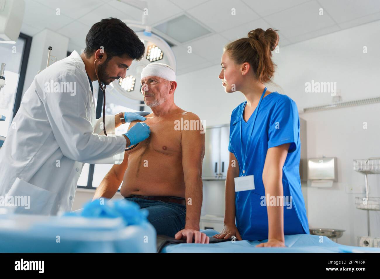 Young doctor and nurse treating injury of senior man Stock Photo - Alamy