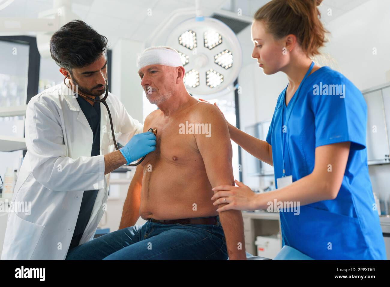 Young doctor and nurse treating injury of senior man Stock Photo - Alamy