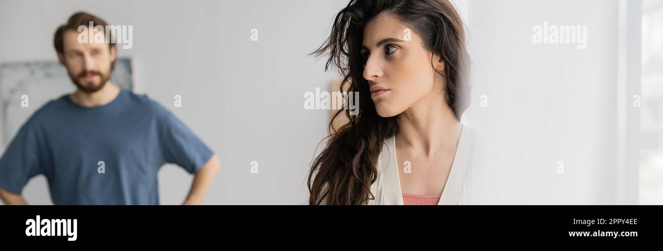 Angry woman standing near blurred boyfriend during relationship ...