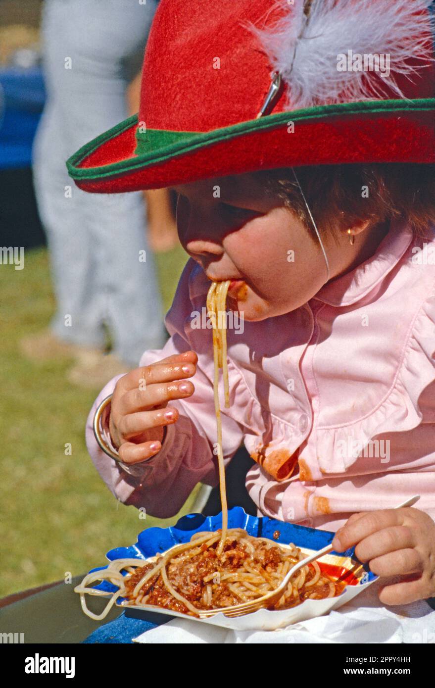 Australia. Darwin Festival. Little girl child outdoors, eating ...