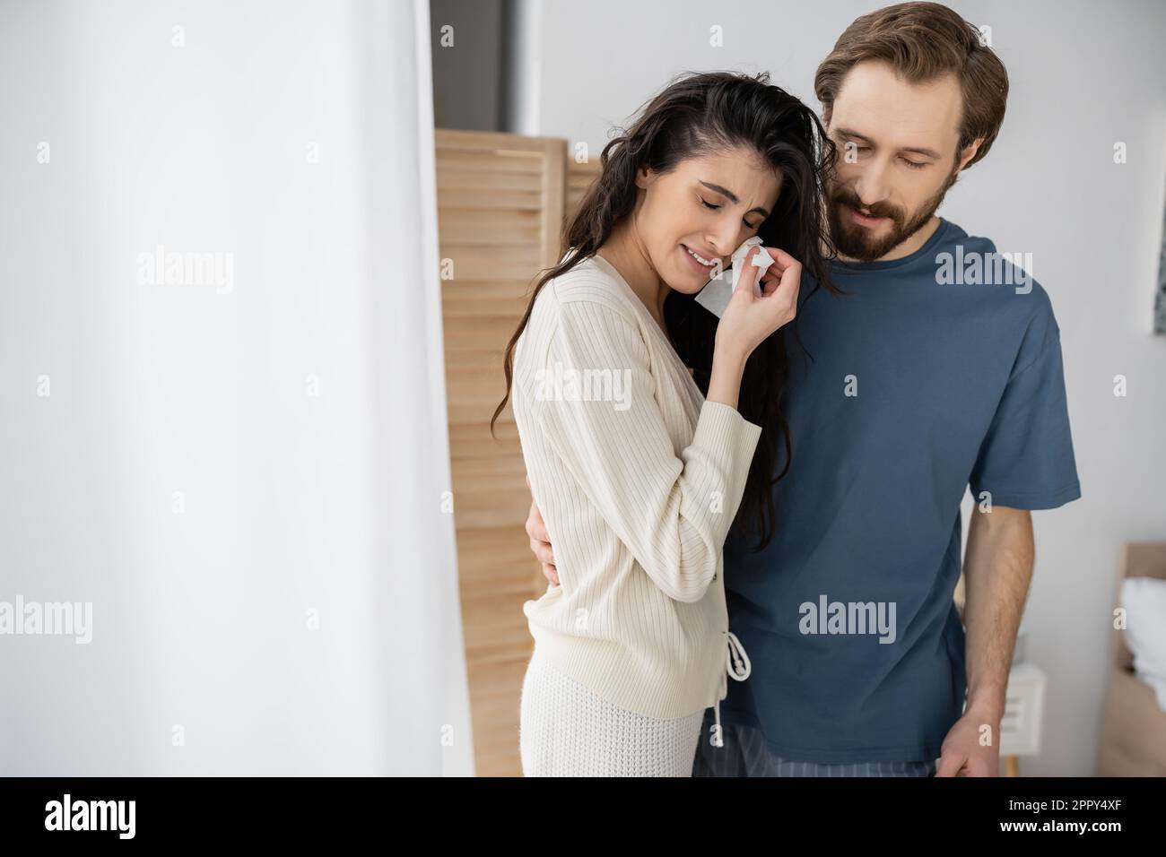 Bearded man hugging and calming crying girlfriend at home,stock image ...