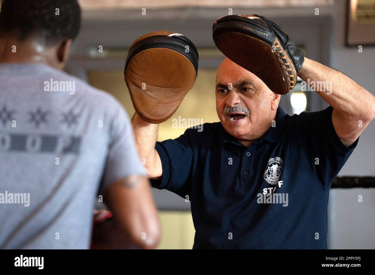Coach George Hernandez holds mits for Theon Davis, 21, as he trains for ...