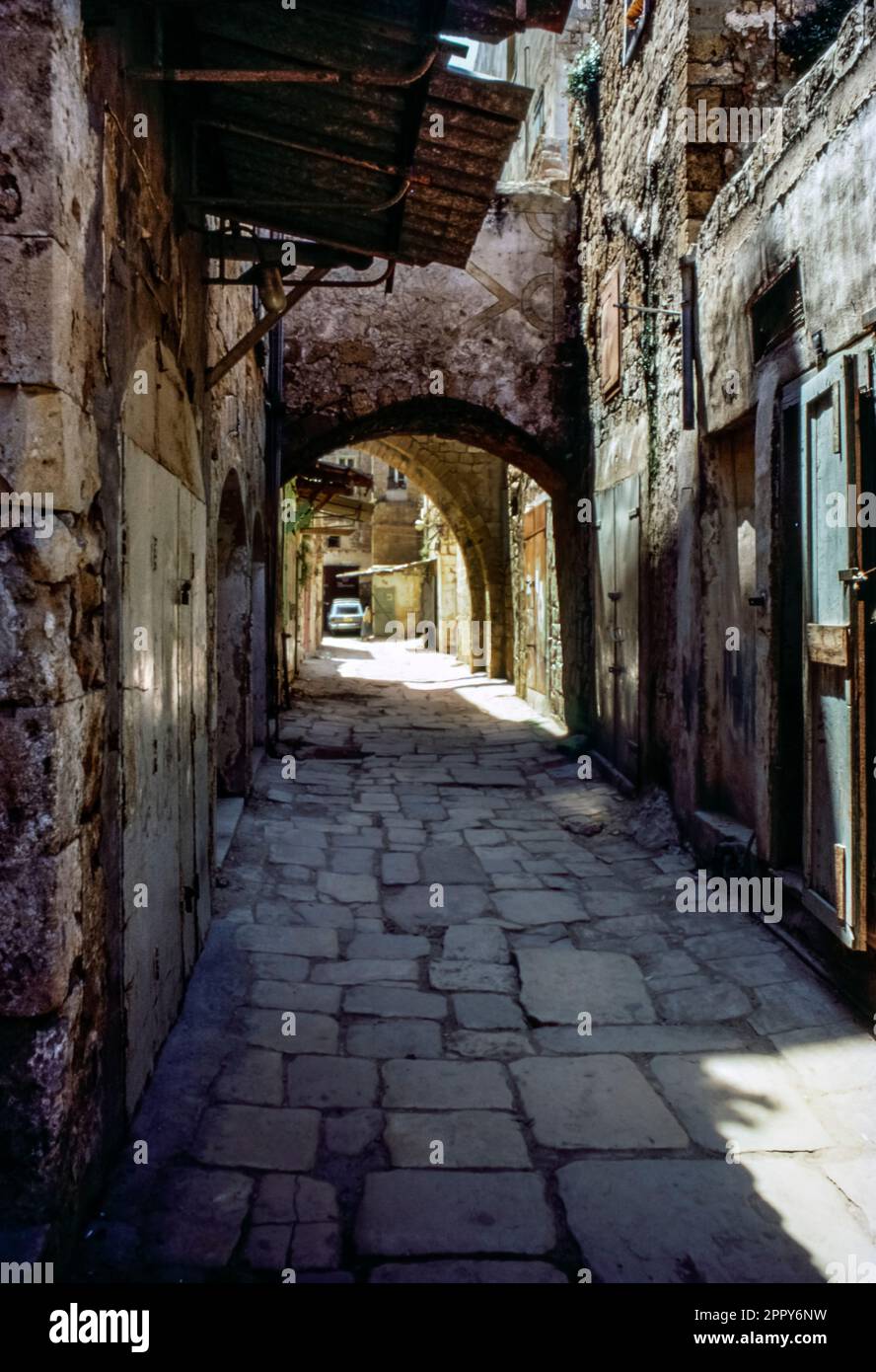 Cobbled back street and stone buildings in the old city of Acre ...