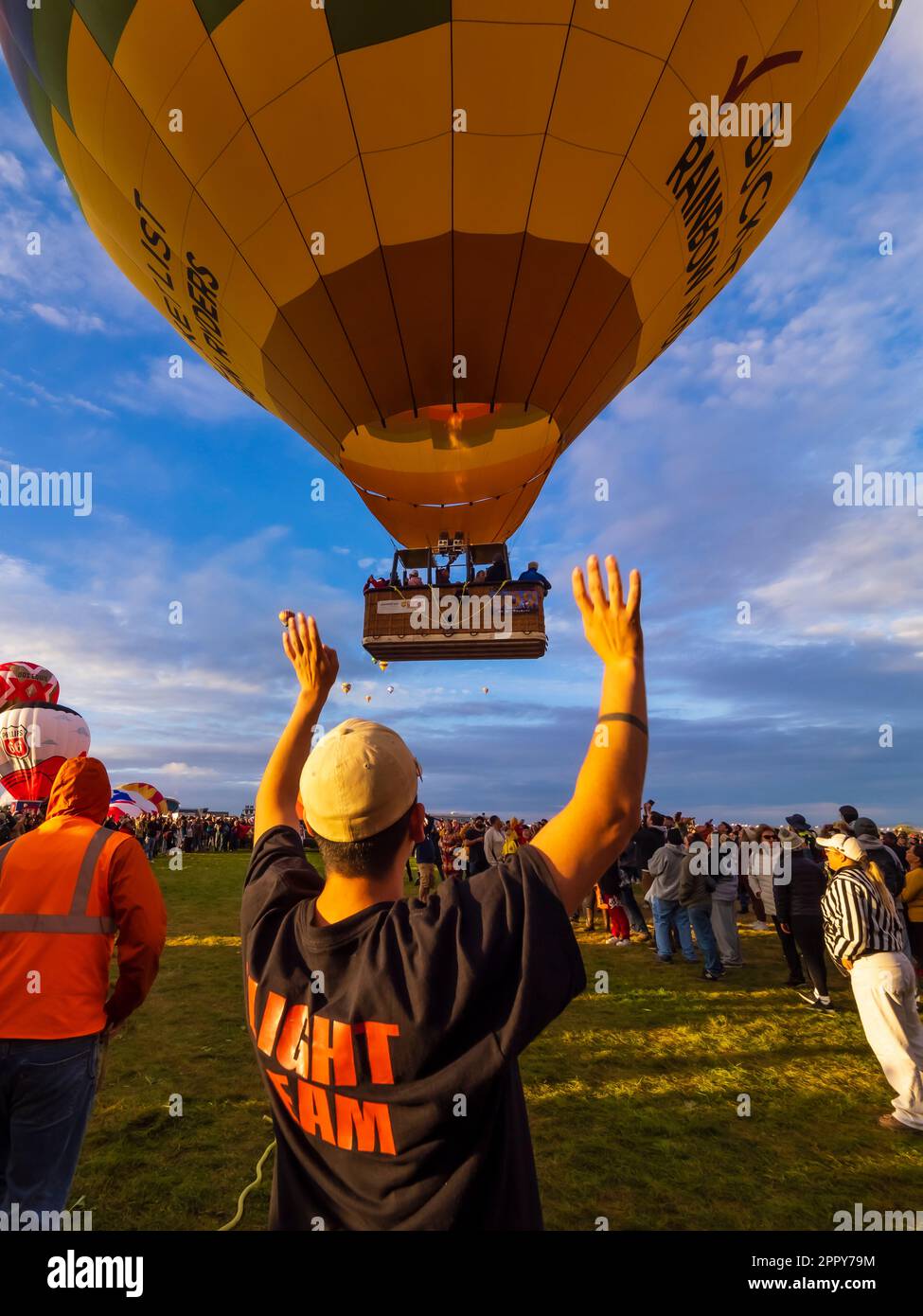 Flight team personnel waving to people in basket of a hot air balloon ...