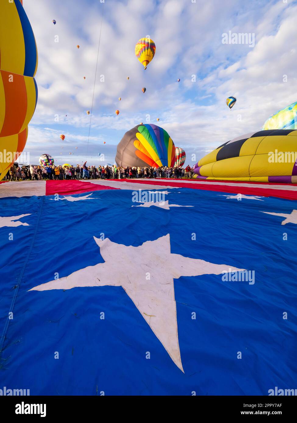 Low angle view from large American flag of a group of hot air balloons ...