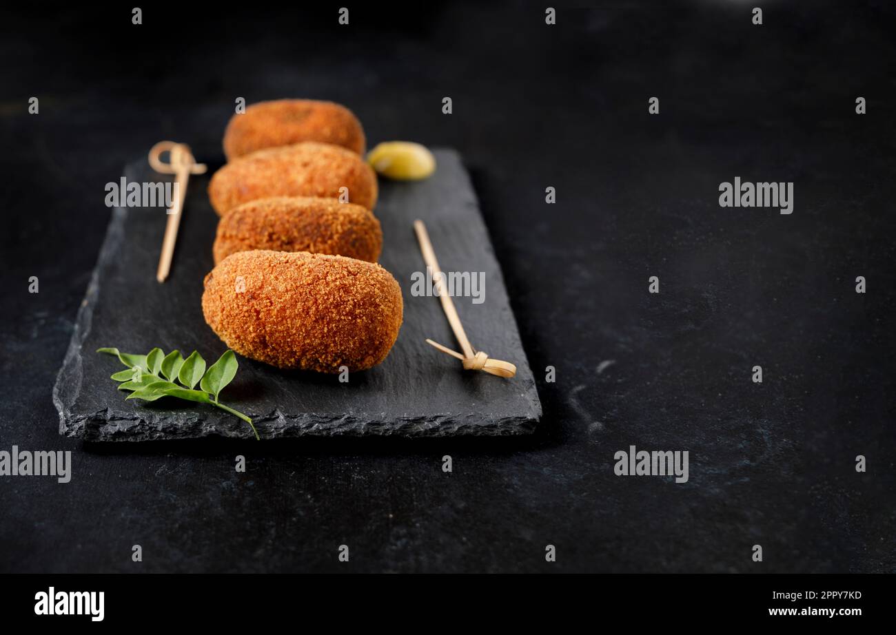 Serving of gourmet style ham croquettes with a black background Stock ...
