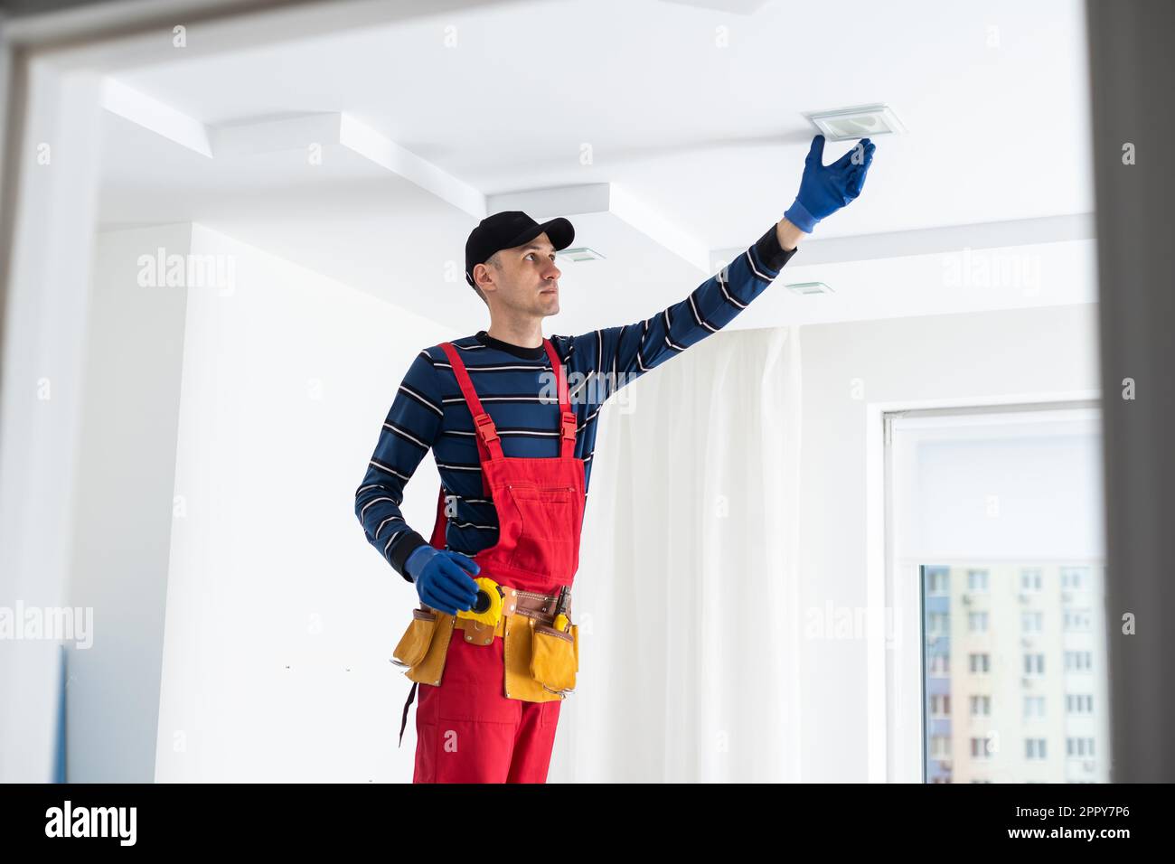 man plasterer construction worker at work, takes plaster from bucket ...