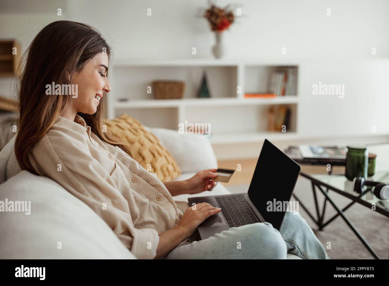 Positive millennial european female typing on computer, use credit card ...