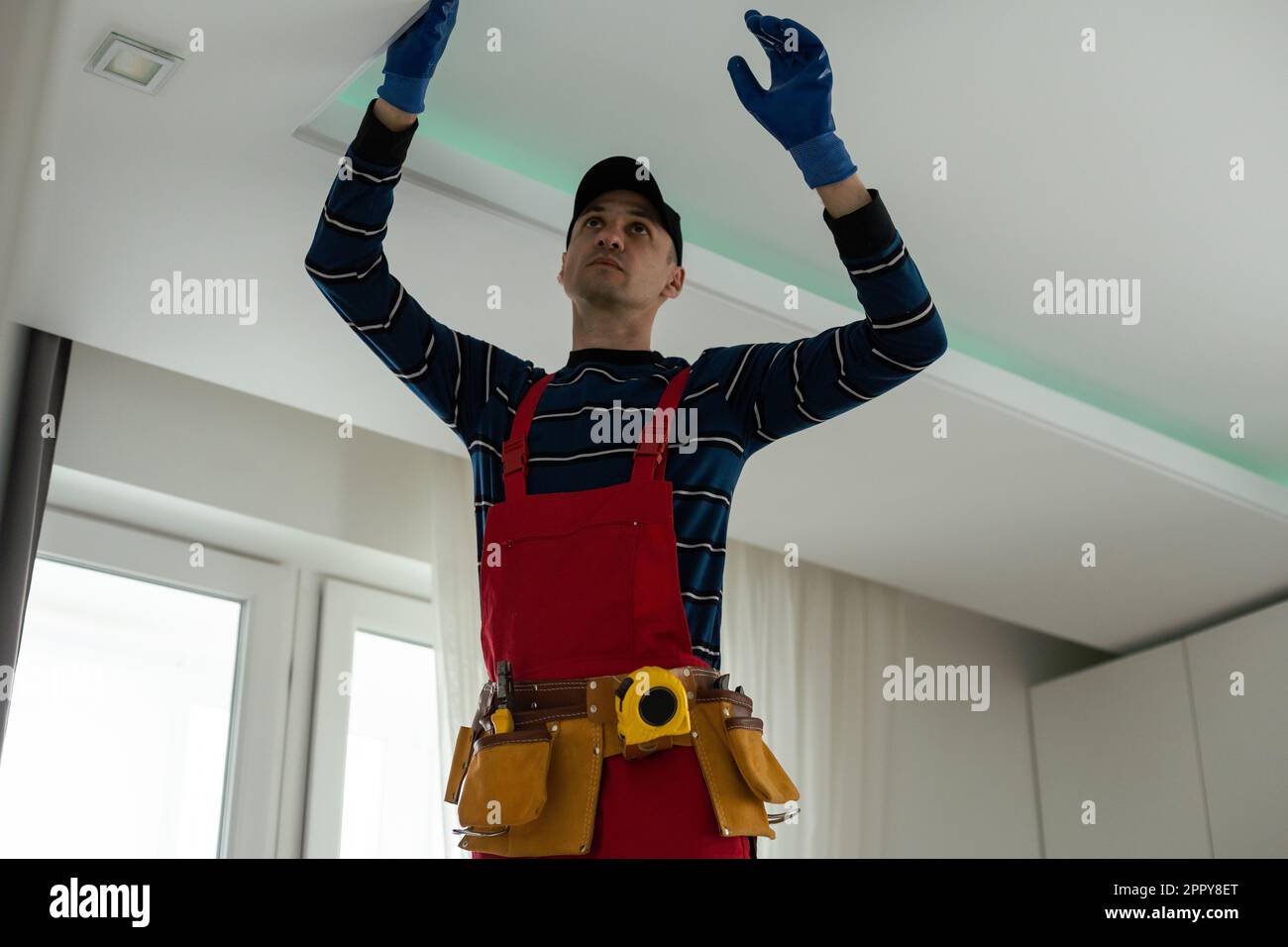man plasterer construction worker at work, takes plaster from bucket ...