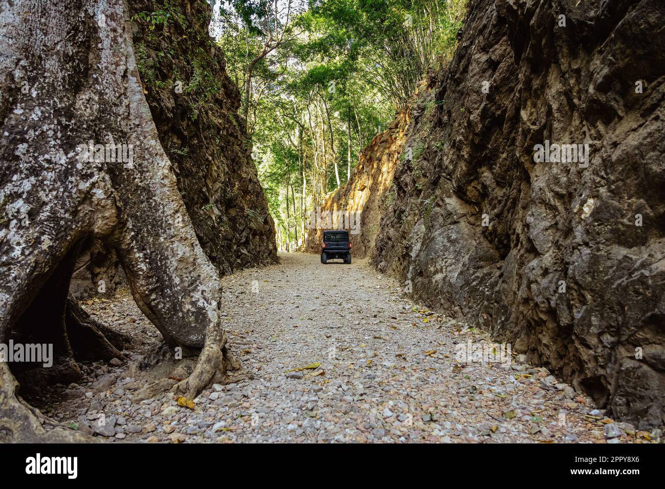 Tourist SUV car cruising along a rugged route through the gorge that ...