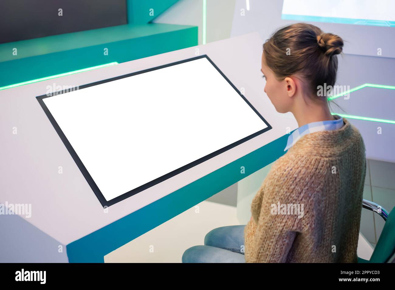 Woman using interactive empty white touchscreen display kiosk at ...