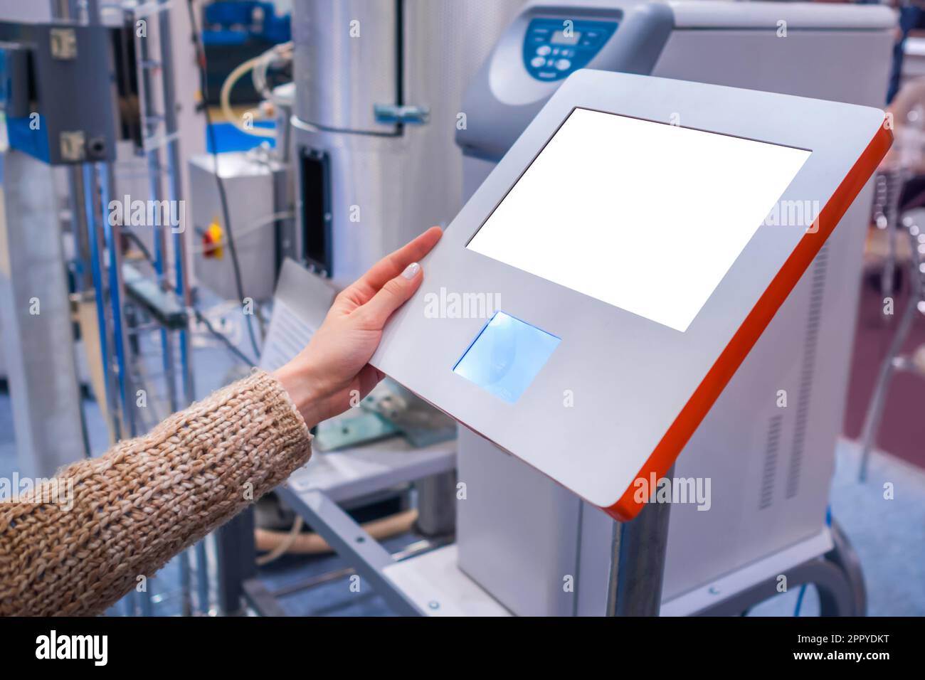 Woman using interactive empty white touchscreen display kiosk at ...
