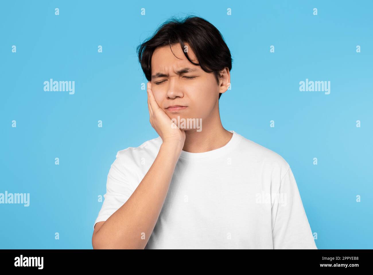 Asian Teenager Guy Suffering From Toothache Touching Cheek, Blue ...