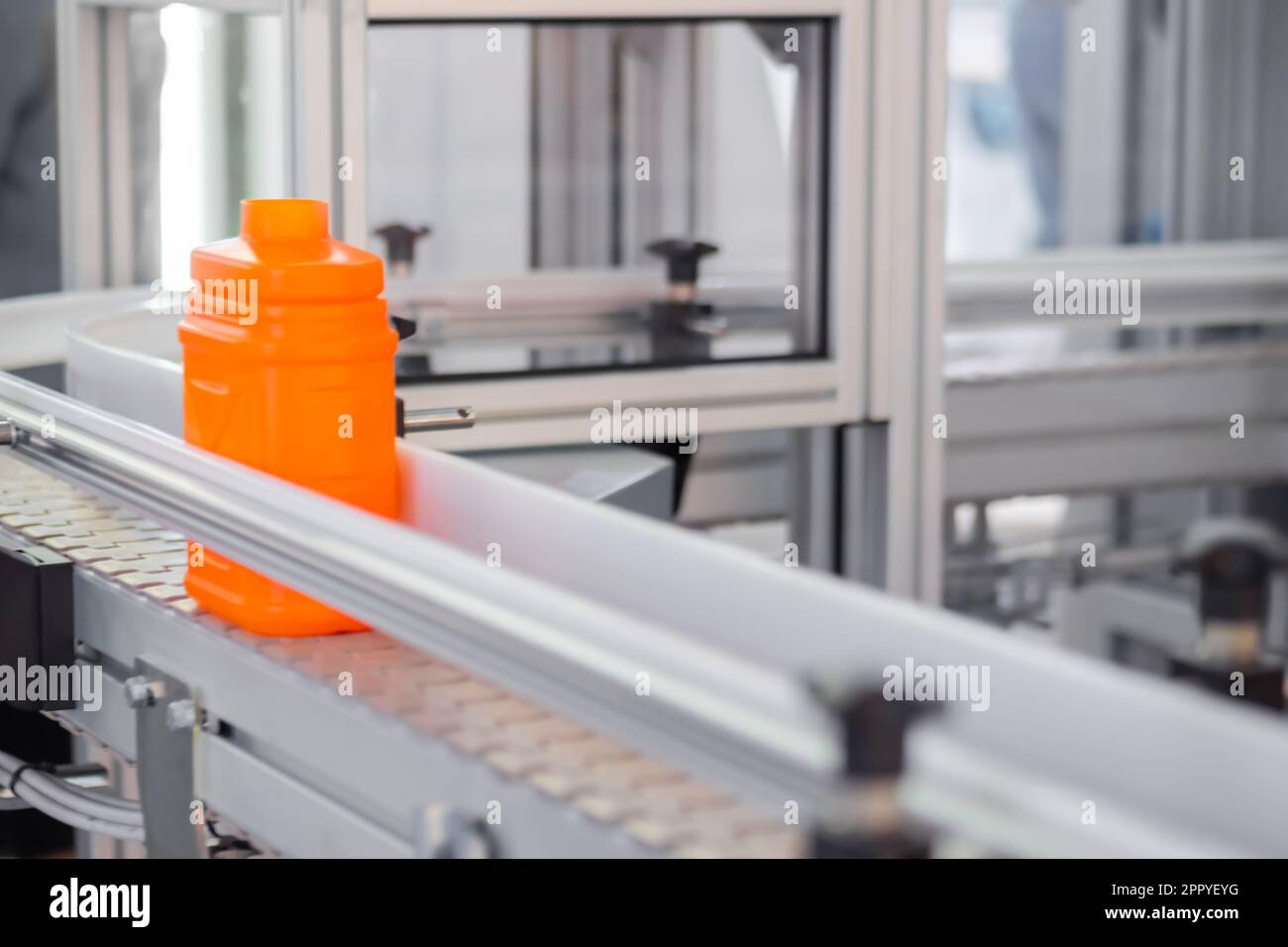 Empty orange plastic jerry can moving on conveyor belt at exhibition ...