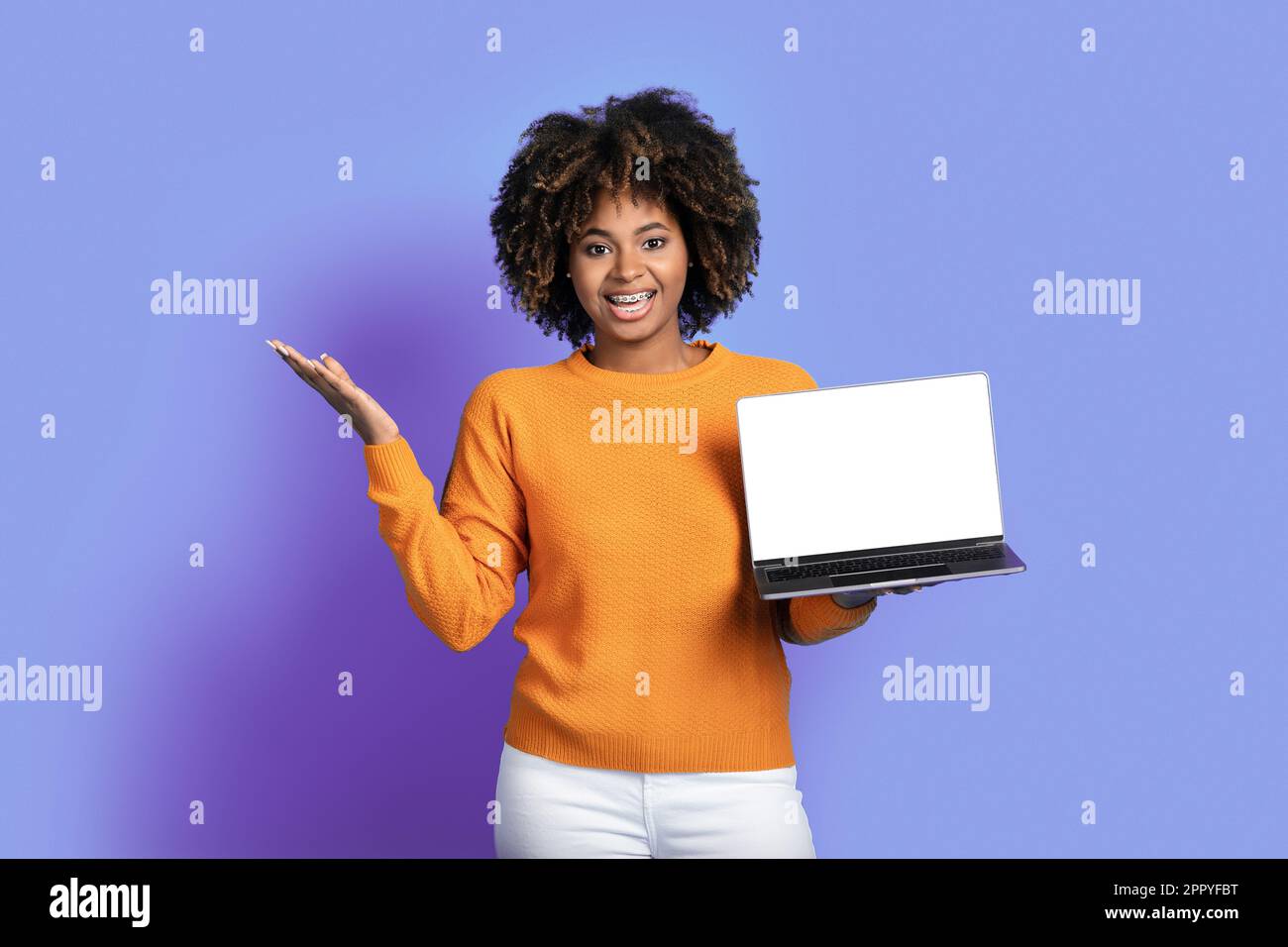 Amazed black woman holding computer with white screen Stock Photo - Alamy
