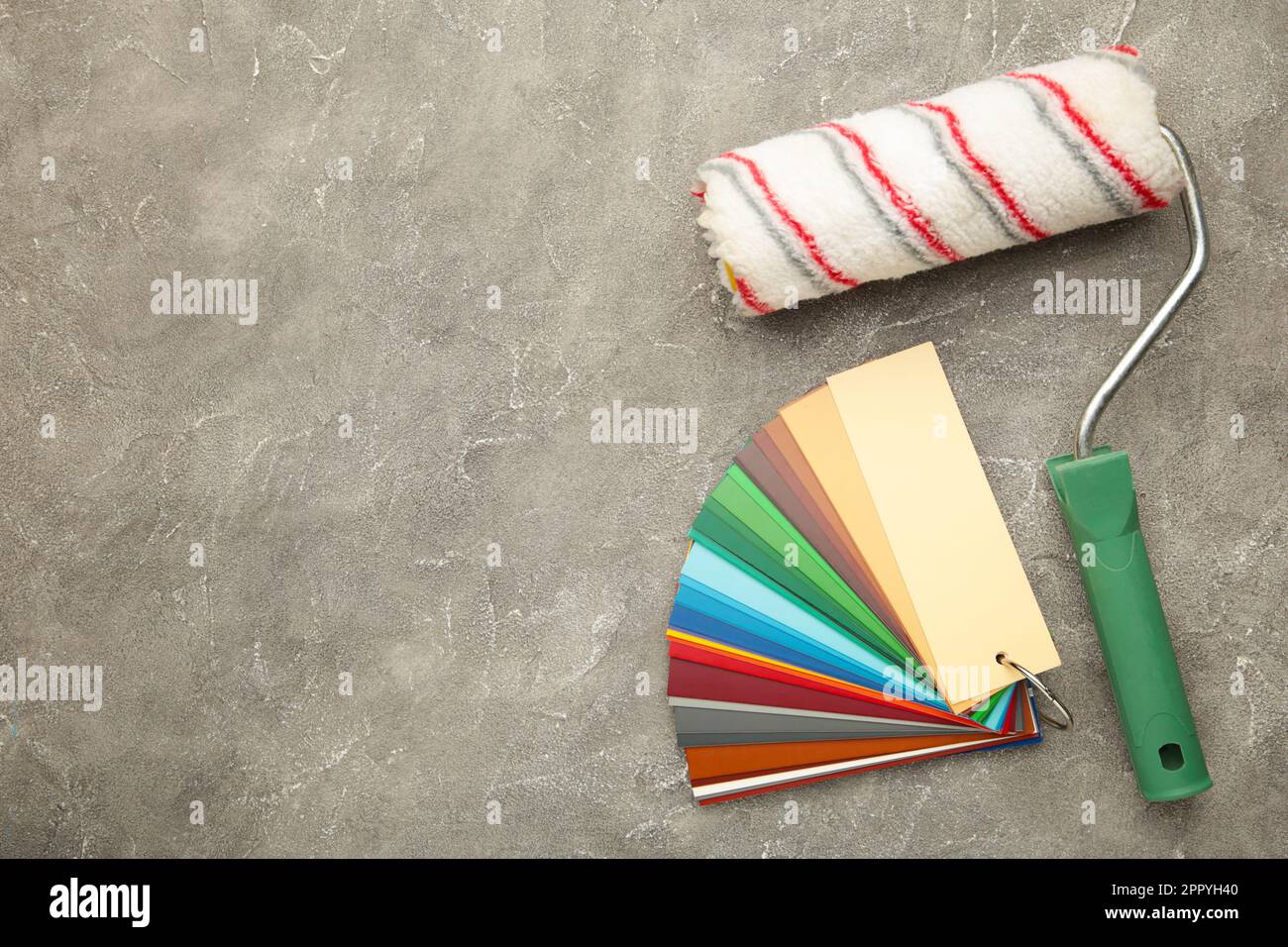 Paint roller brush and color palette guide on grey concrete background ...