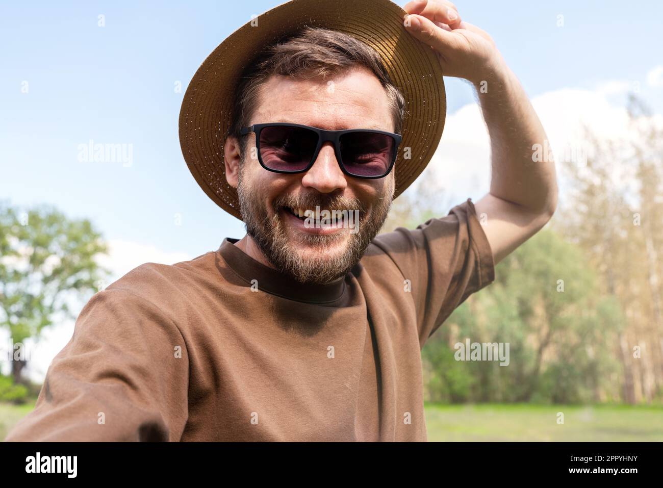 Man Wearing Dark Glasses And Straw Hat Taking A Selfie Outdoors In Summer Mental Wellbeing And