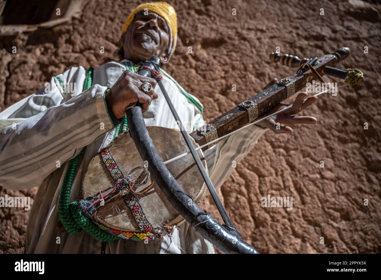Man dressed in typical Berber costume playing a stringed instrument ...