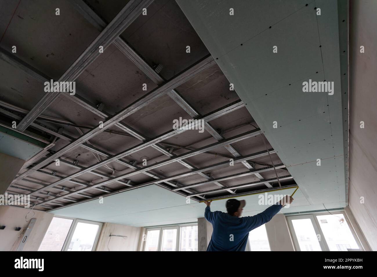 Workers fitting panel into frame of ceiling Stock Photo - Alamy