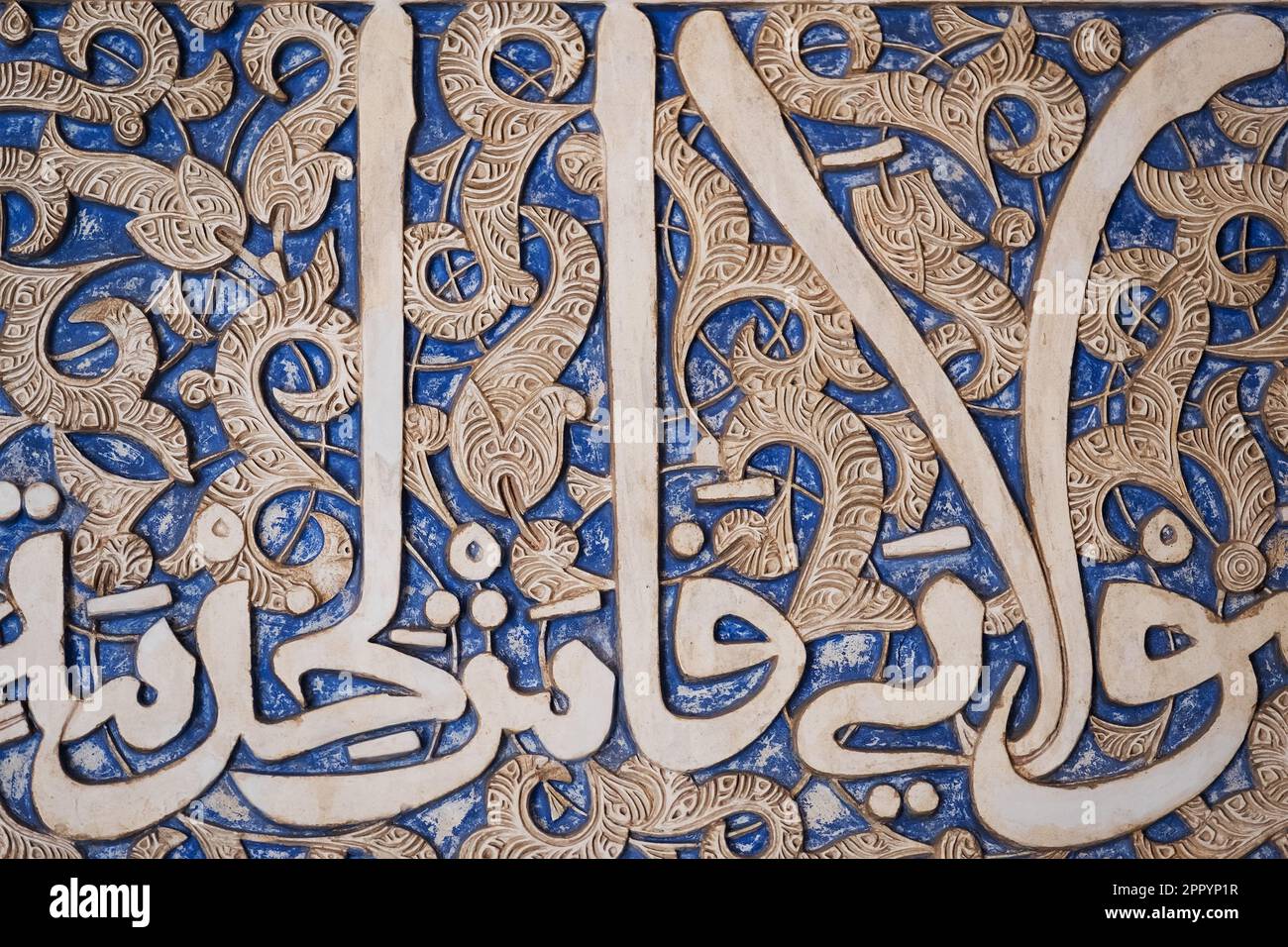 Details of stucco decoration with an Arabic writings painted in blue on ...