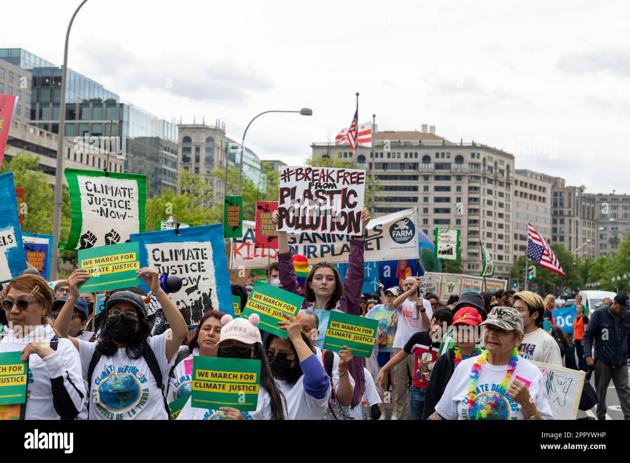 A group of people holding signs and marching to the White House at the ...