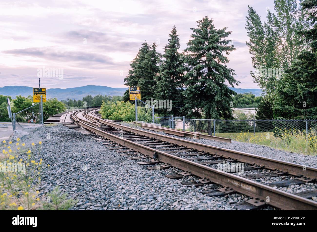 An idyllic landscape featuring a railroad track, winding its way ...